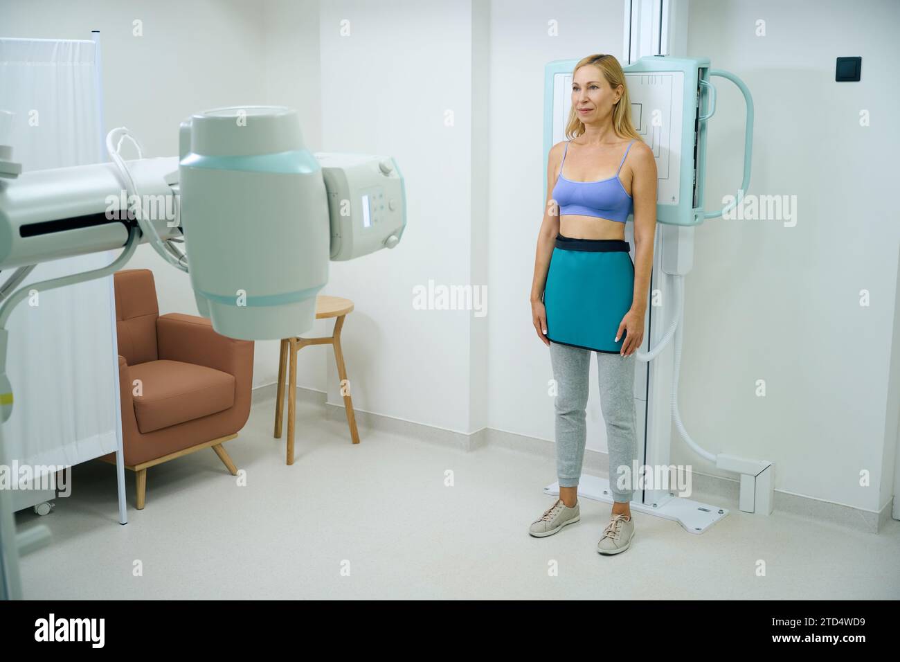 Mature female patient is undergoing thorax radiography in upright ...