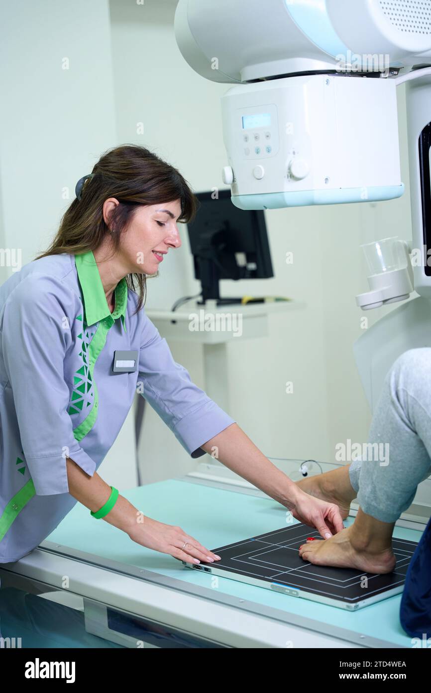 Friendly radiographer is preparing adult person for x-ray of toes Stock ...