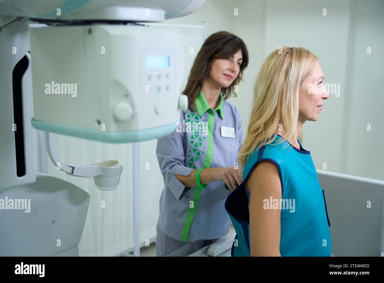Radiologic technologist shielding patient body from harmful radiation ...