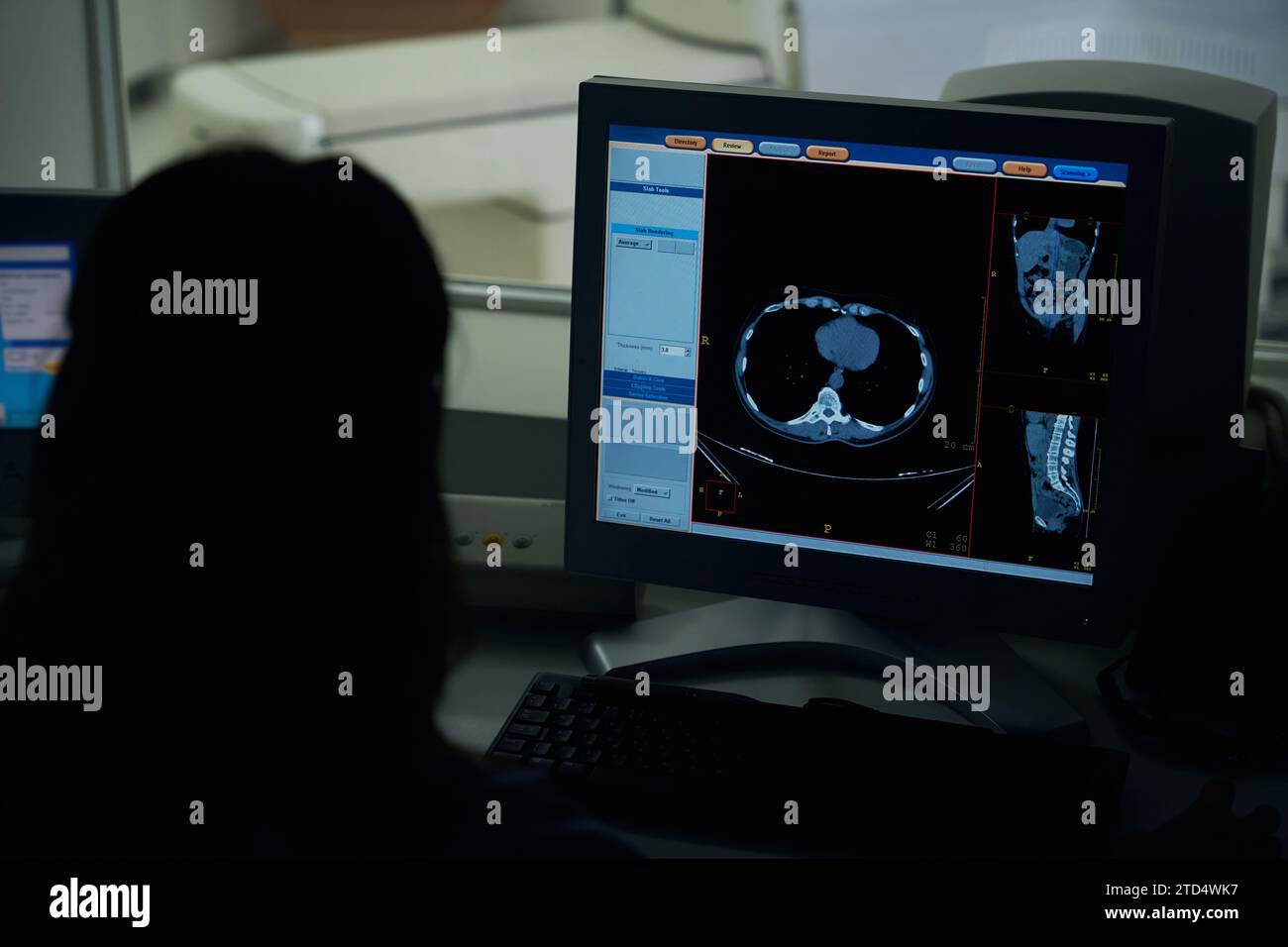 Radiographer performing computed tomography scanning from control room ...