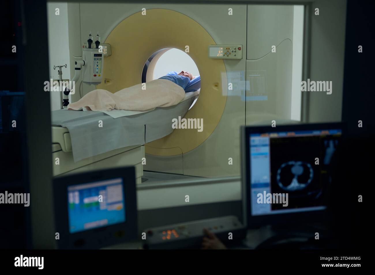 Patient undergoing computed tomography with radiologic technologist ...
