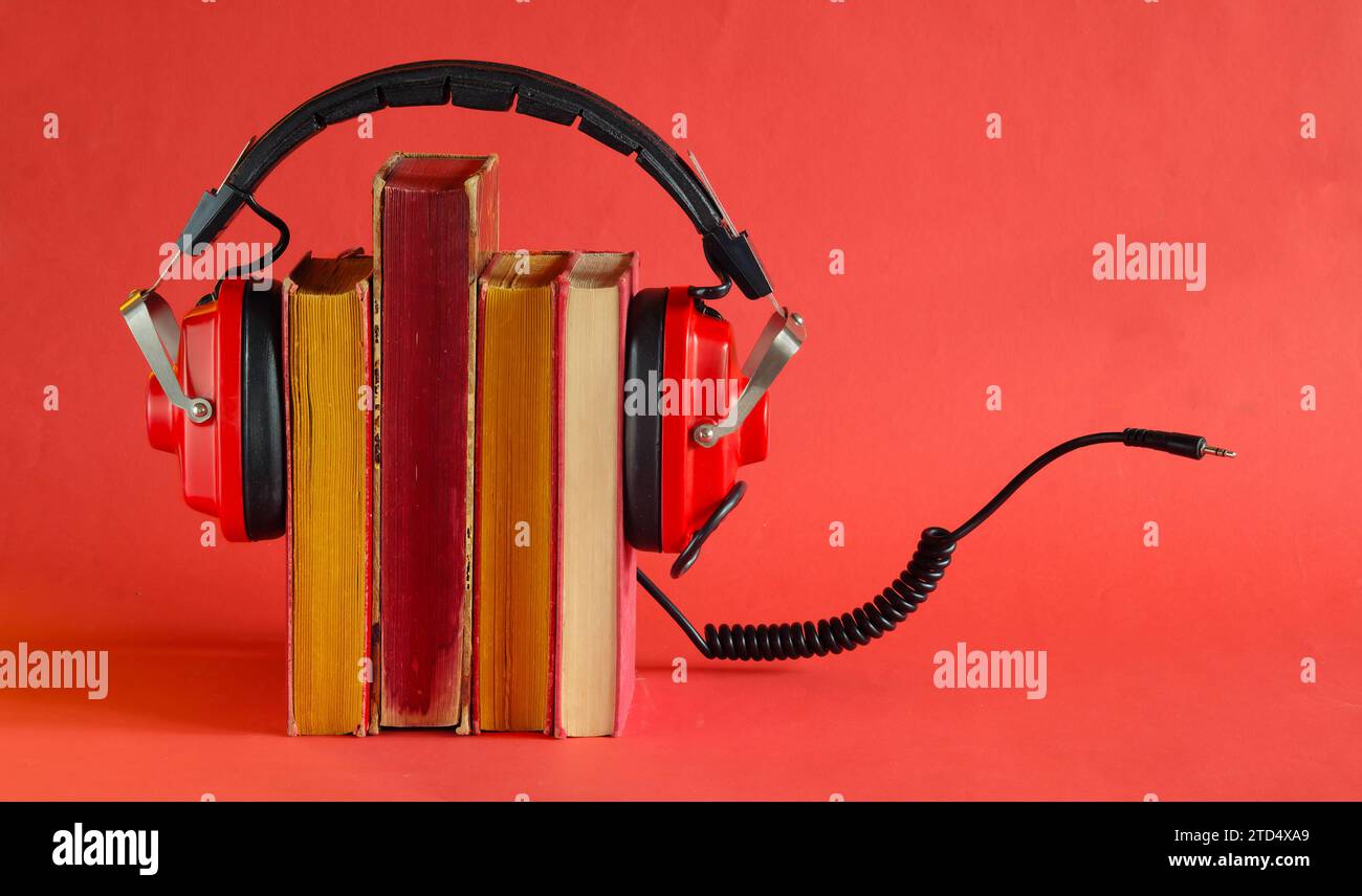 audio book concept with row of books,and vintage headphones, cable and ...