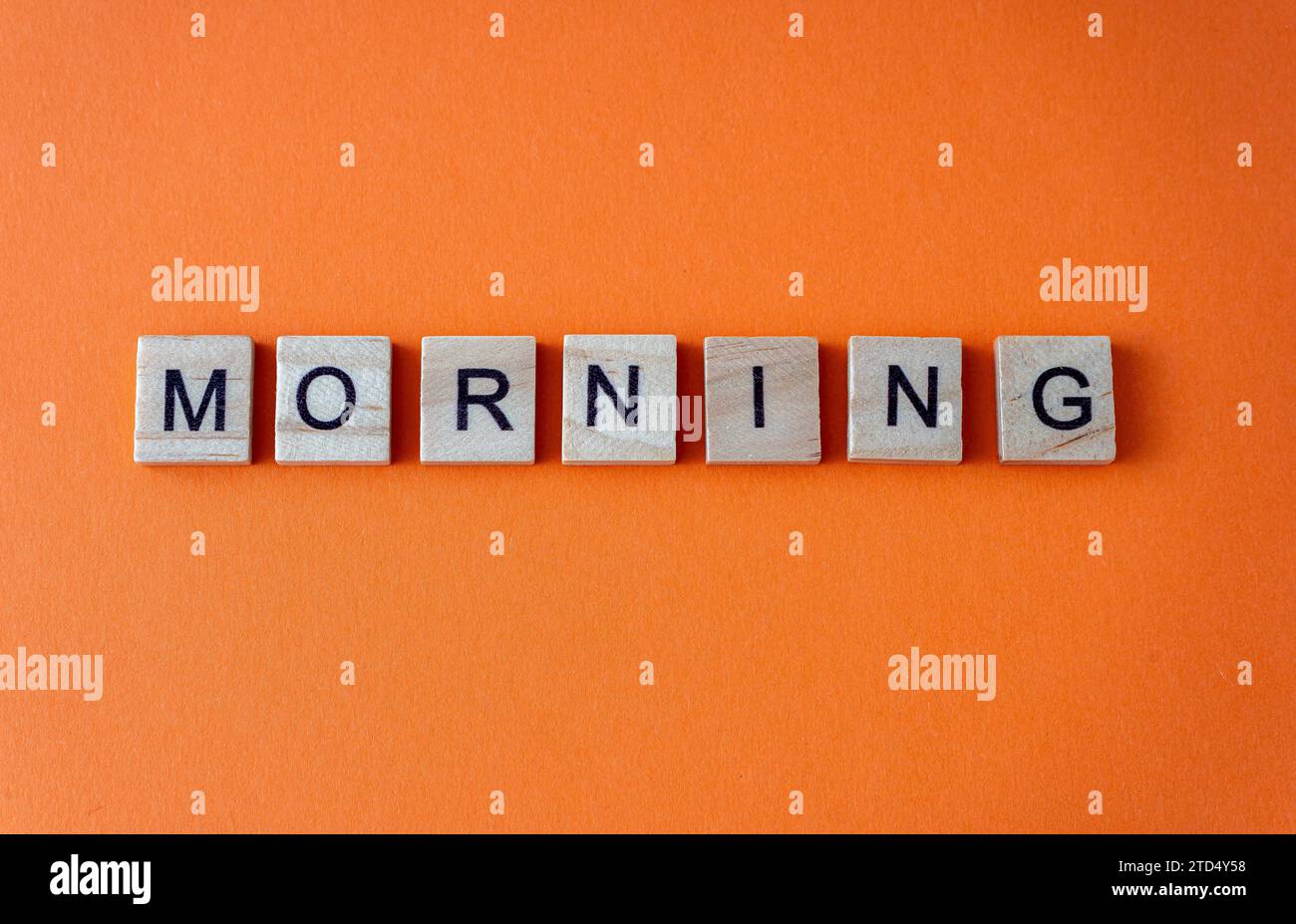 Morning word. The phrase is laid out in wooden letters top view. Orange ...