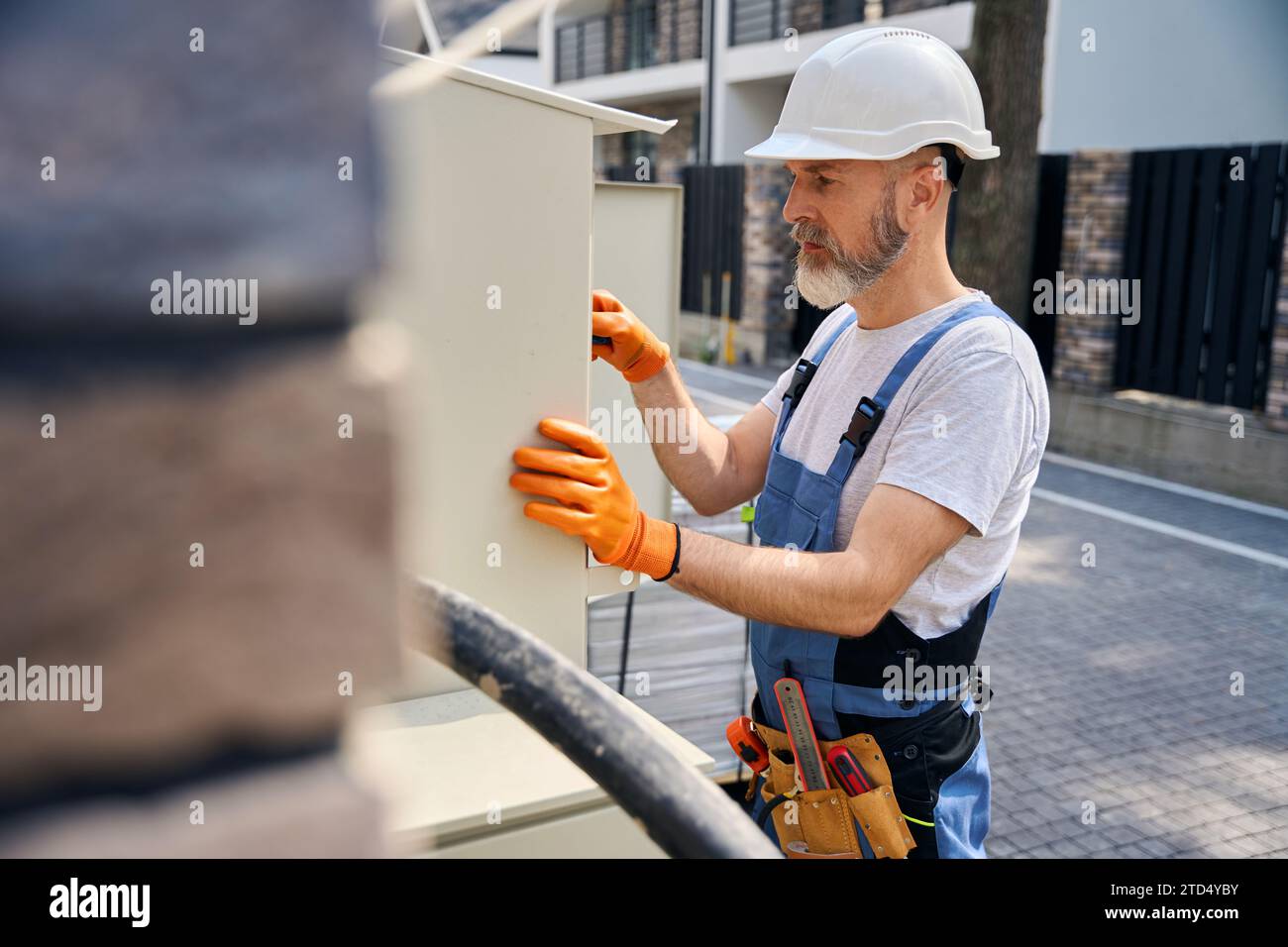 Skilled construction worker repairing external electrical distribution ...