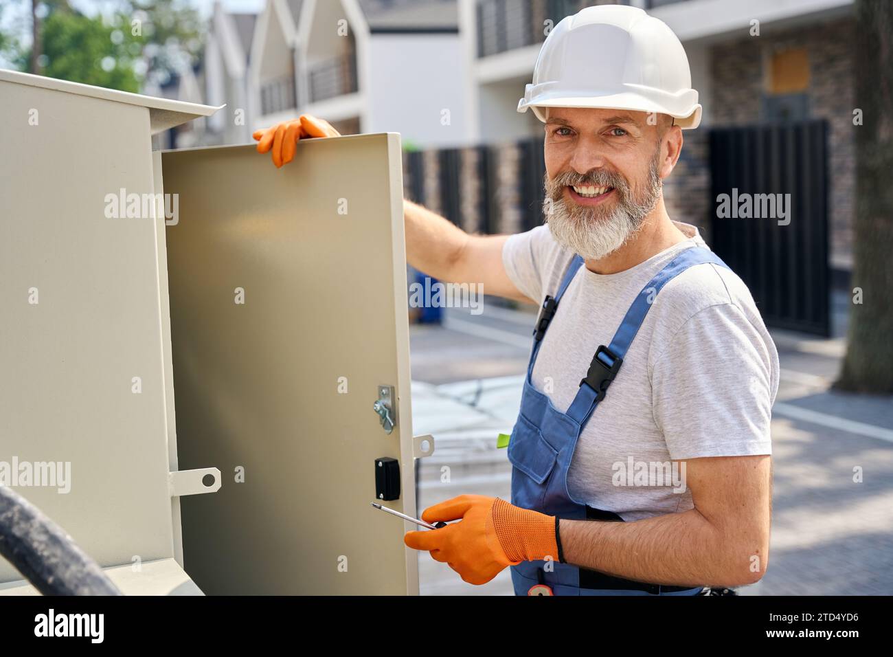Male engineer posing for camera during electric switchboard ...