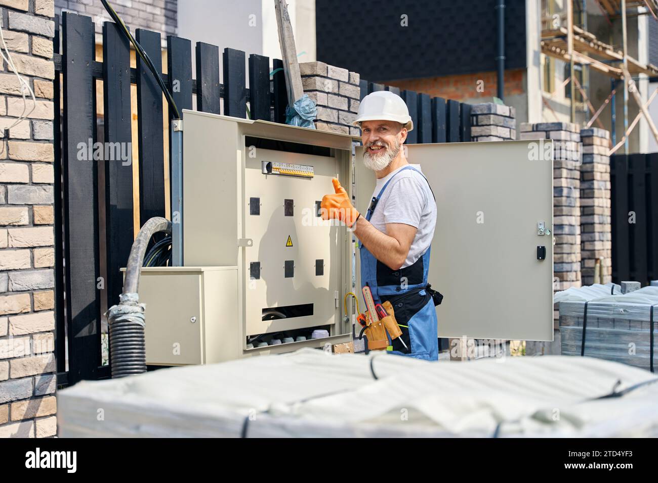 Electrician approving electric switchboard installation on construction ...