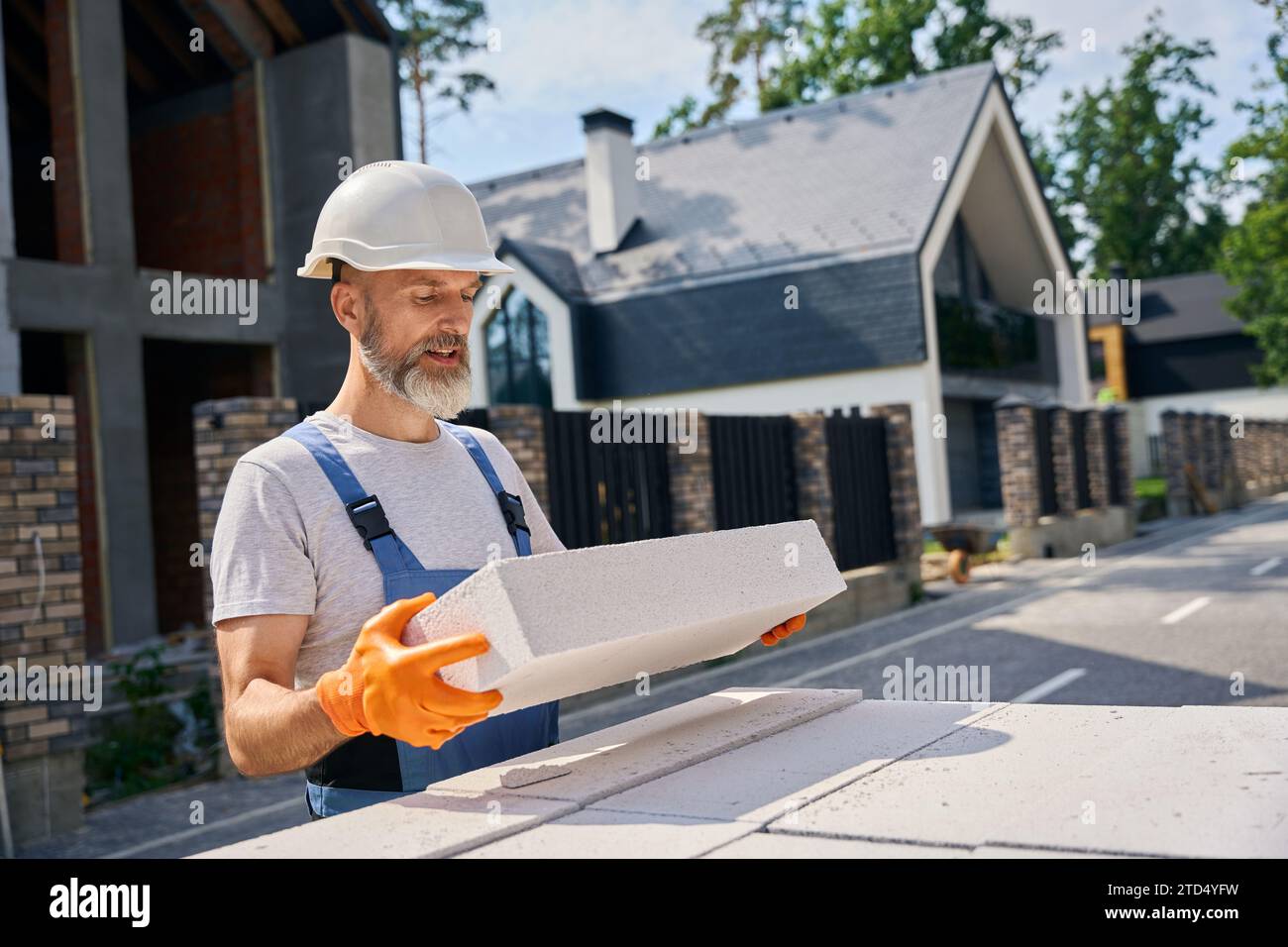 Construction worker examining building materials before masonry work on ...