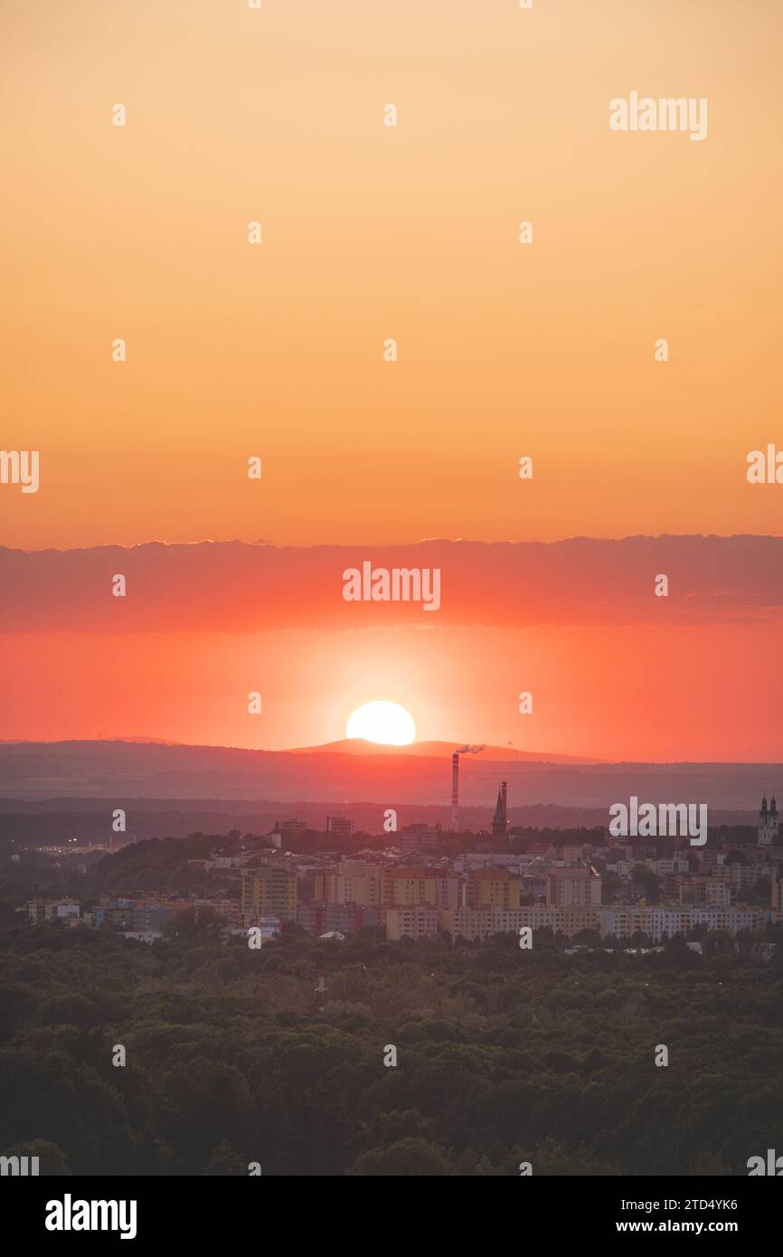 Disc of sunset with reddish hues sets behind the mountains in the ...
