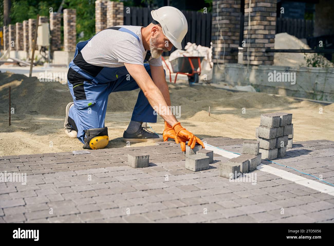 Skilled builder paving road on construction site Stock Photo - Alamy