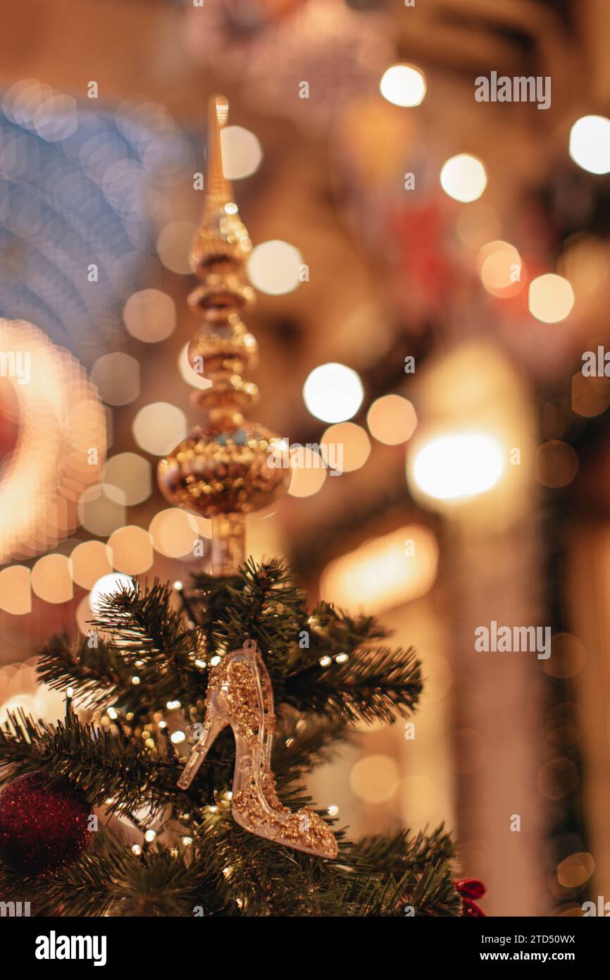 Golden Cinderella's magical shoe hanging on the Christmas tree. Winter ...