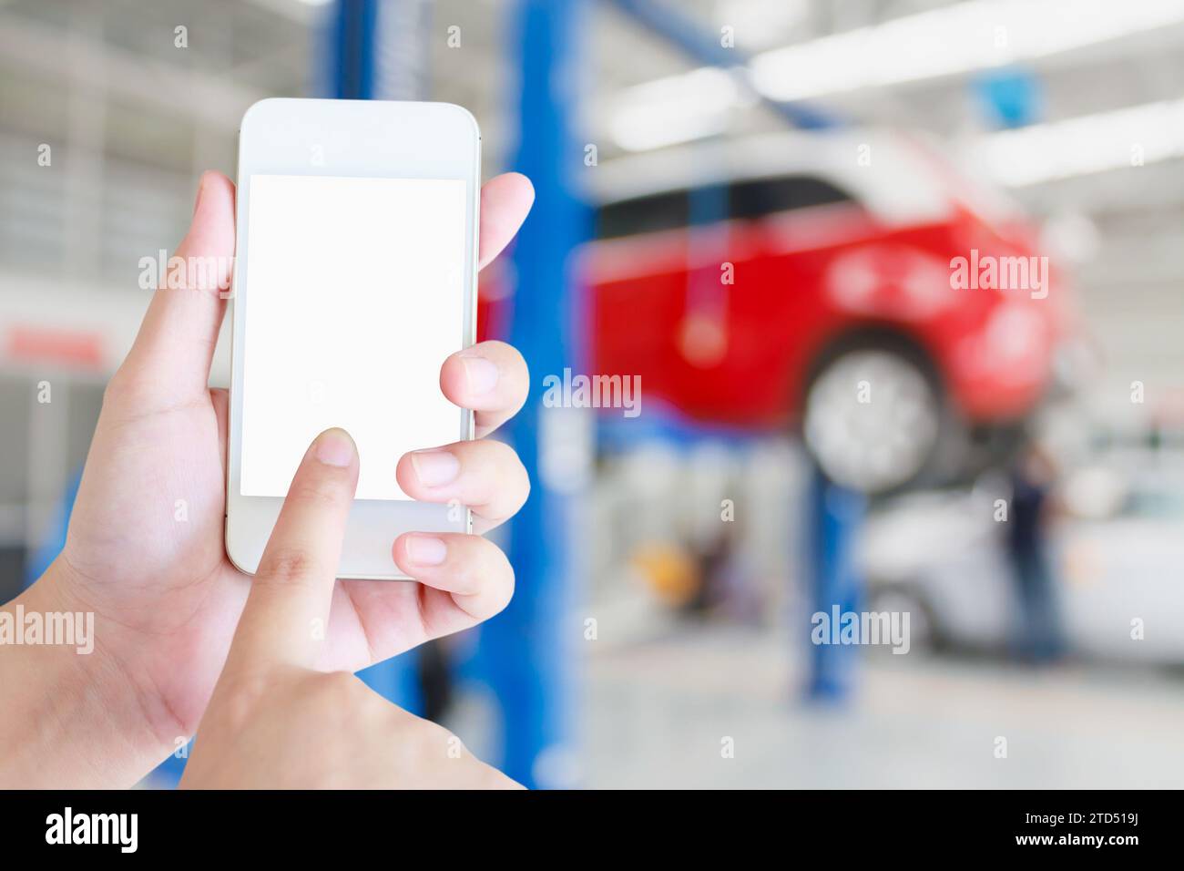 woman hand hold touch screen mobile smart phone with car garage ...