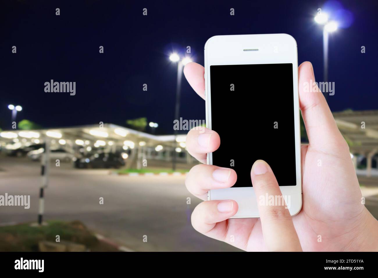 Mobile hold in hand with blur cars parking Stock Photo - Alamy
