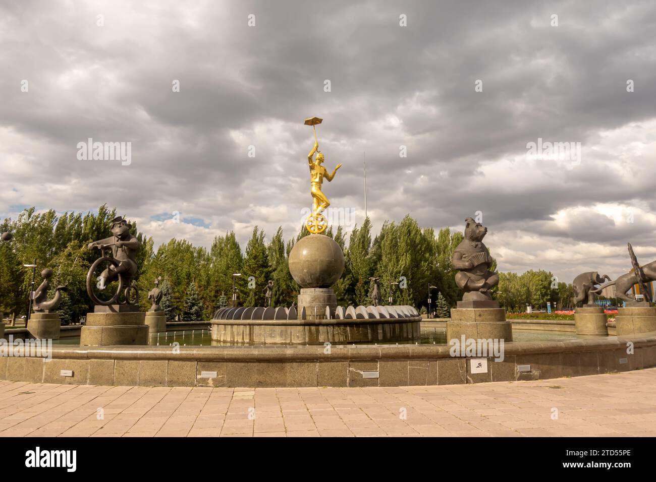 A fountain with a gilded statue of a circus performer on a monowheel ...