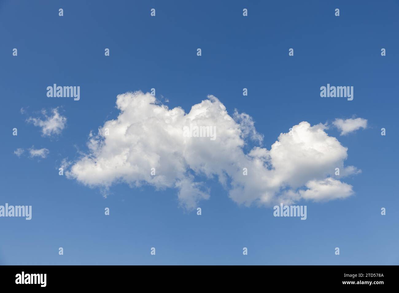 A solitary, large cumulus cloud stands out against a blue sky ...