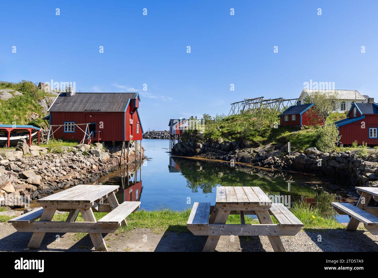 Red traditional wooden cabins (Rorbu) perched on rocky shores in ...