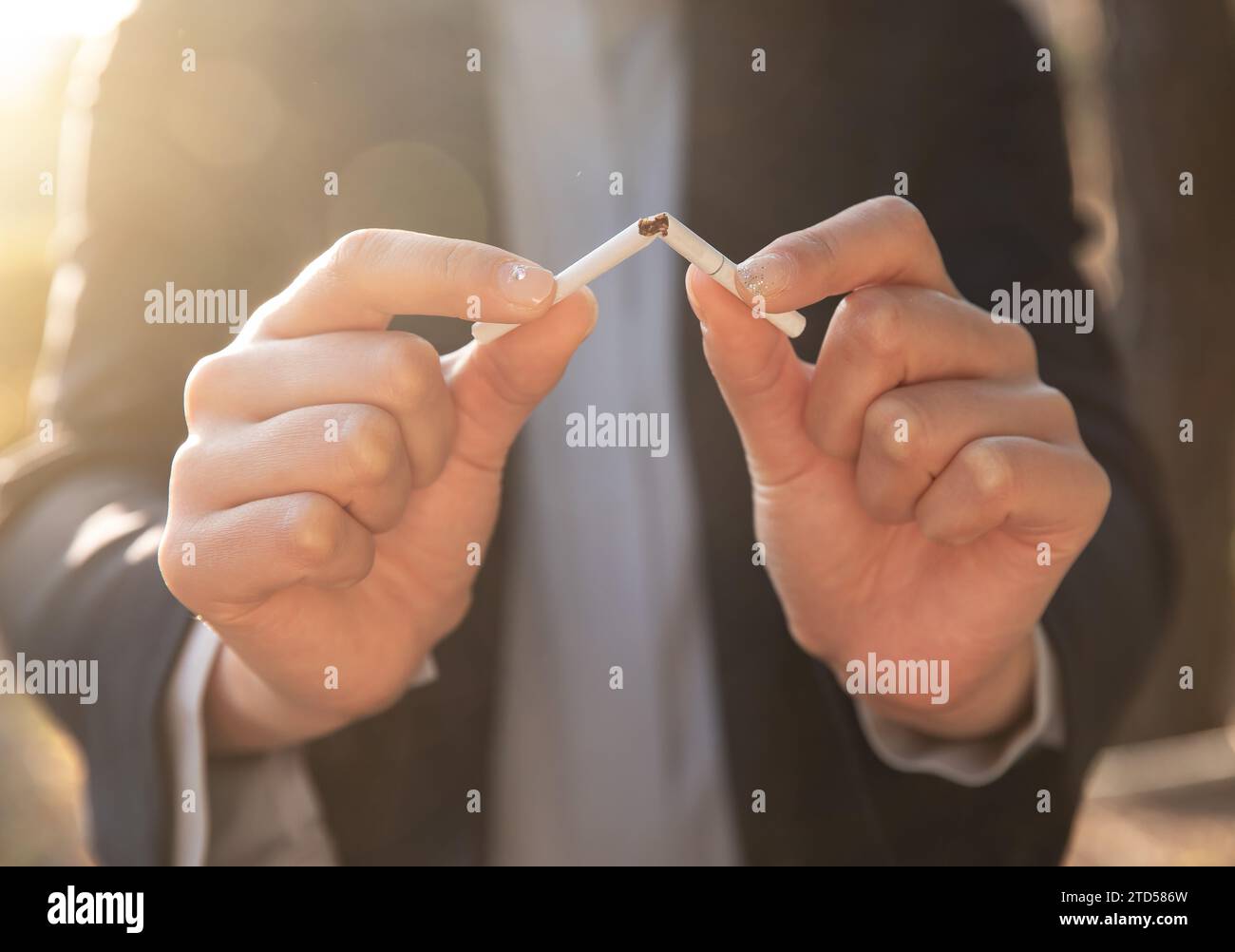 A woman decides to quit smoking and is breaking a cigarette Stock Photo ...