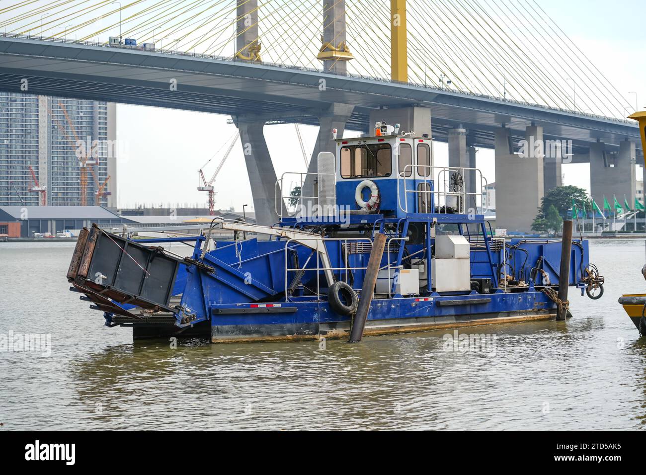 Ship blue with a claw manipulator hand parked at the port pier under ...