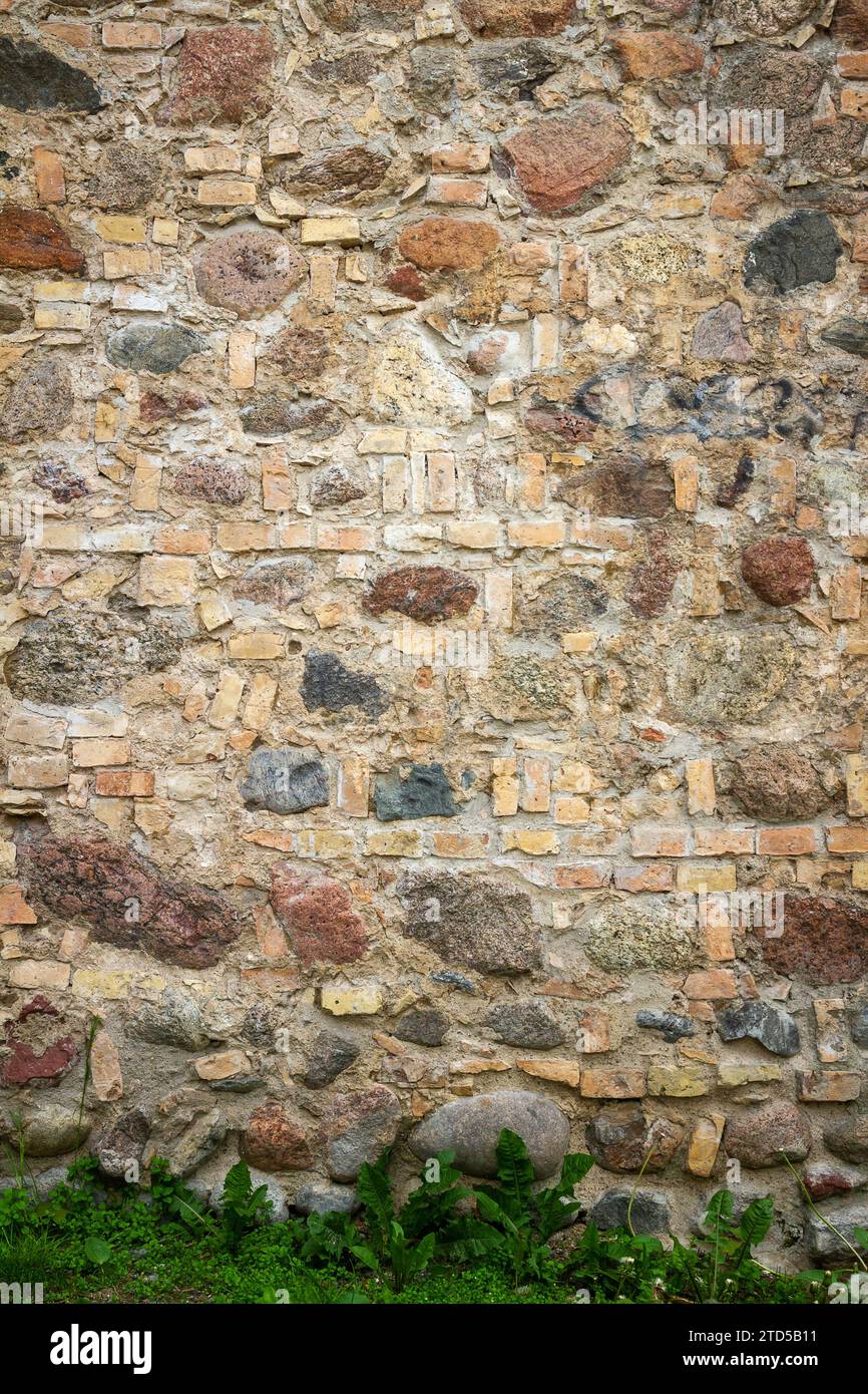 Wall texture with pieces of old bricks mixed with exposed round stones ...