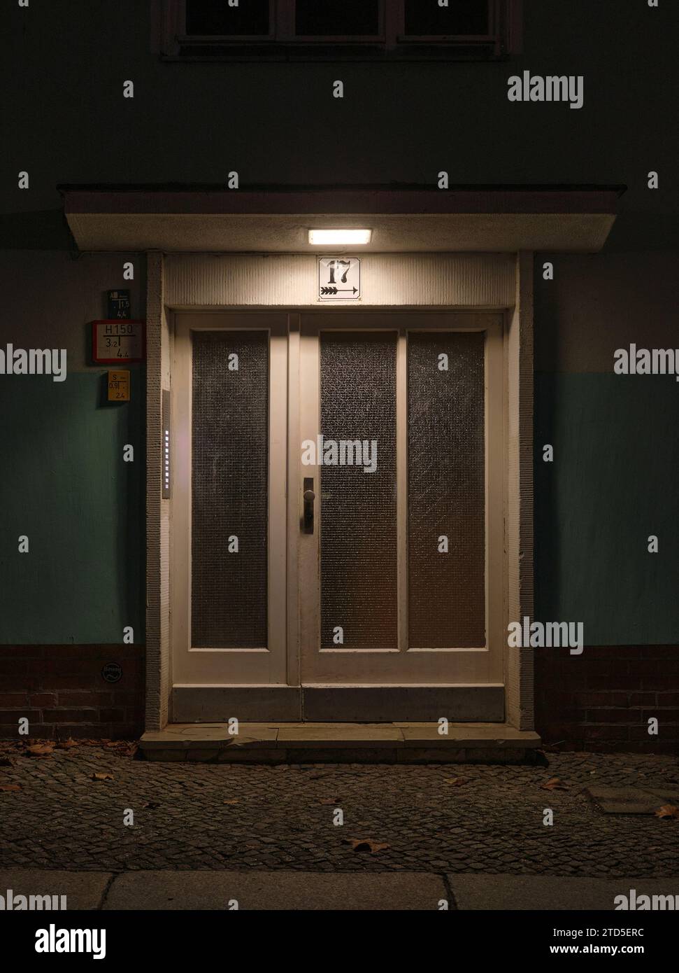 Nightly illuminated front door of a typical post-war building from the ...
