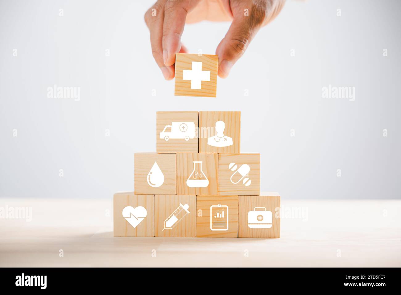 Hand hold wooden block with icon healthcare medical Stock Photo - Alamy