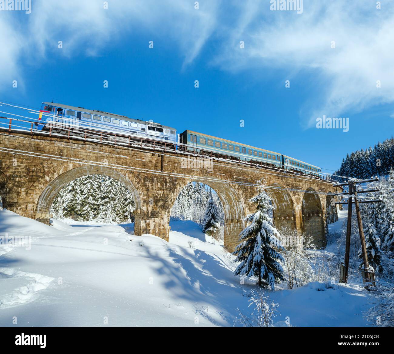 Stone viaduct (arch bridge) on railway through mountain snowy fir ...