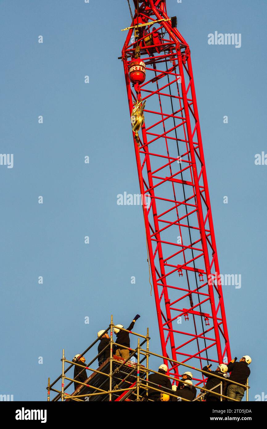 The new golden rooster containing relics is lifted by crane to be ...