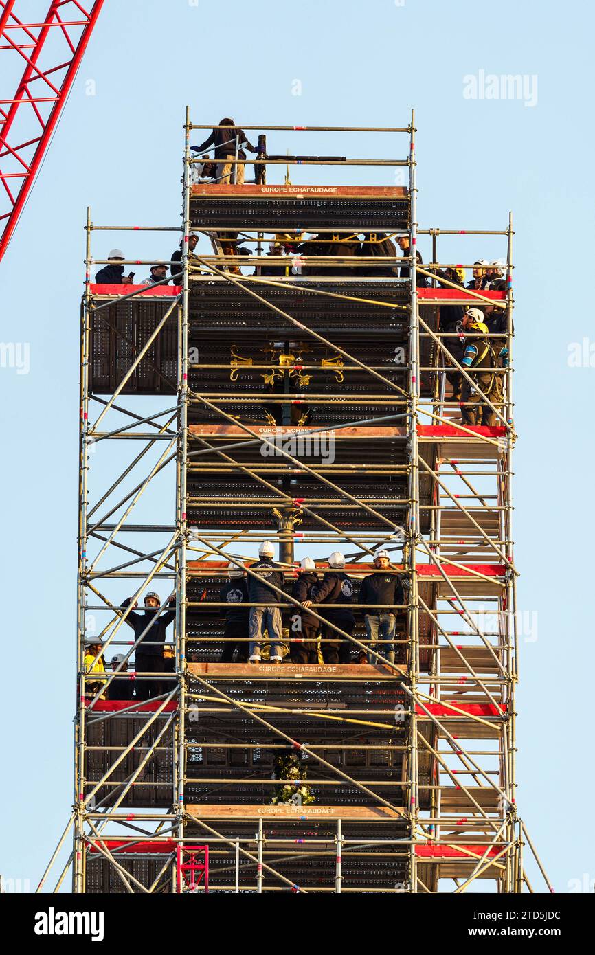 The new golden rooster containing relics is lifted by crane to be ...