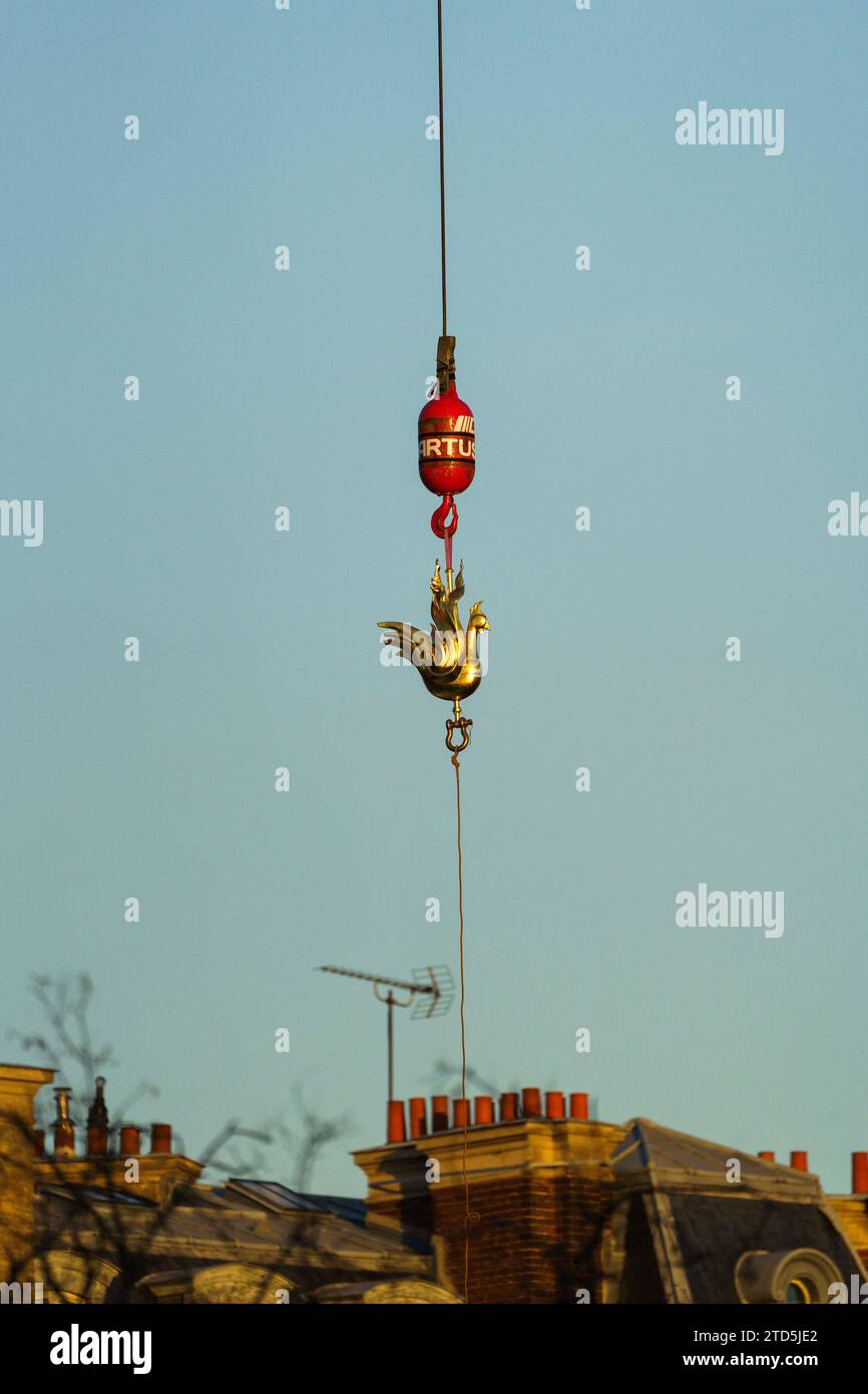 The new golden rooster containing relics is lifted by crane to be ...