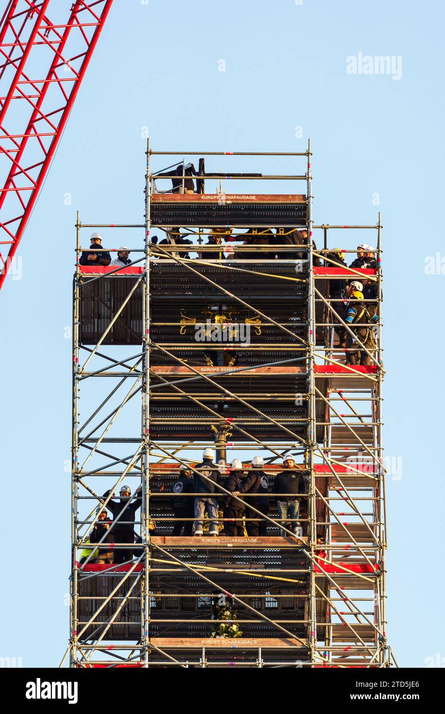The new golden rooster containing relics is lifted by crane to be ...