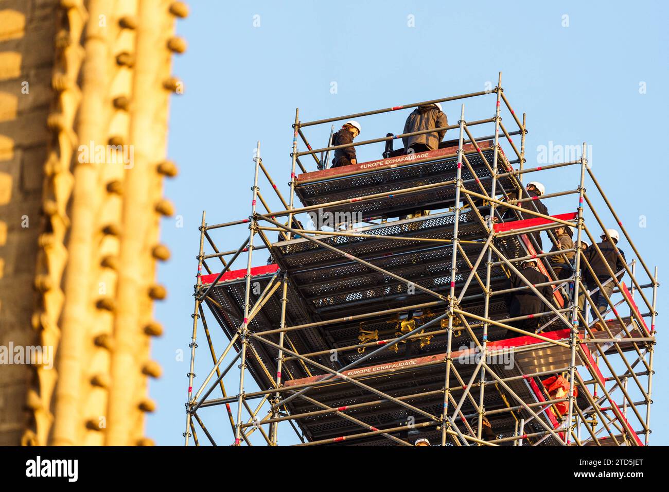 The new golden rooster containing relics is lifted by crane to be ...