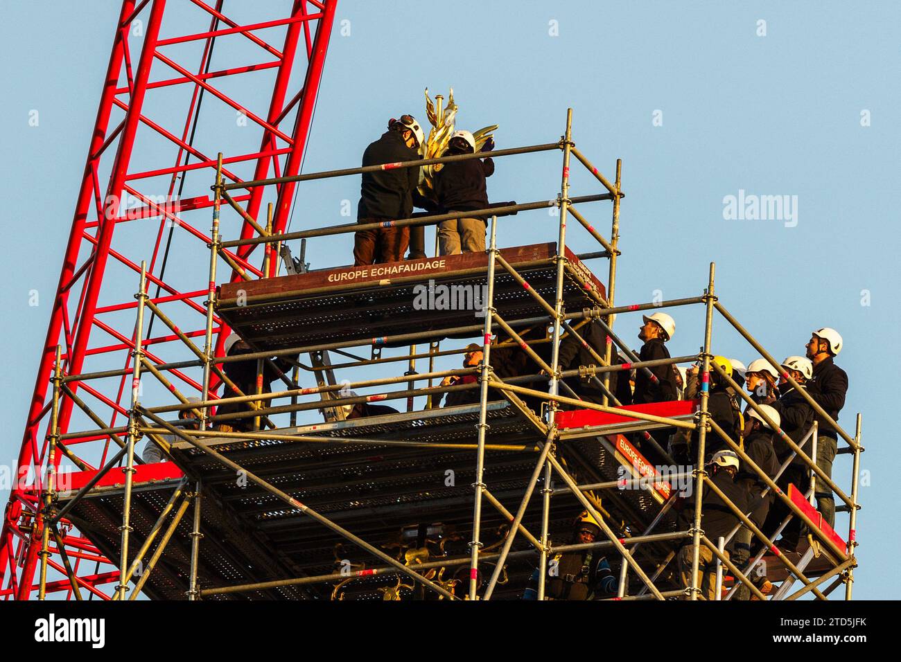 The new golden rooster containing relics is lifted by crane to be ...