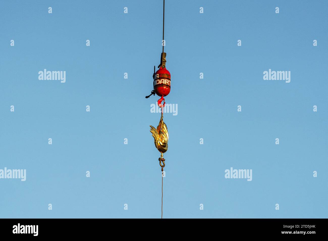 The new golden rooster containing relics is lifted by crane to be ...