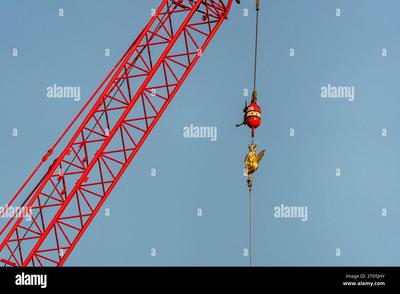 The new golden rooster containing relics is lifted by crane to be ...
