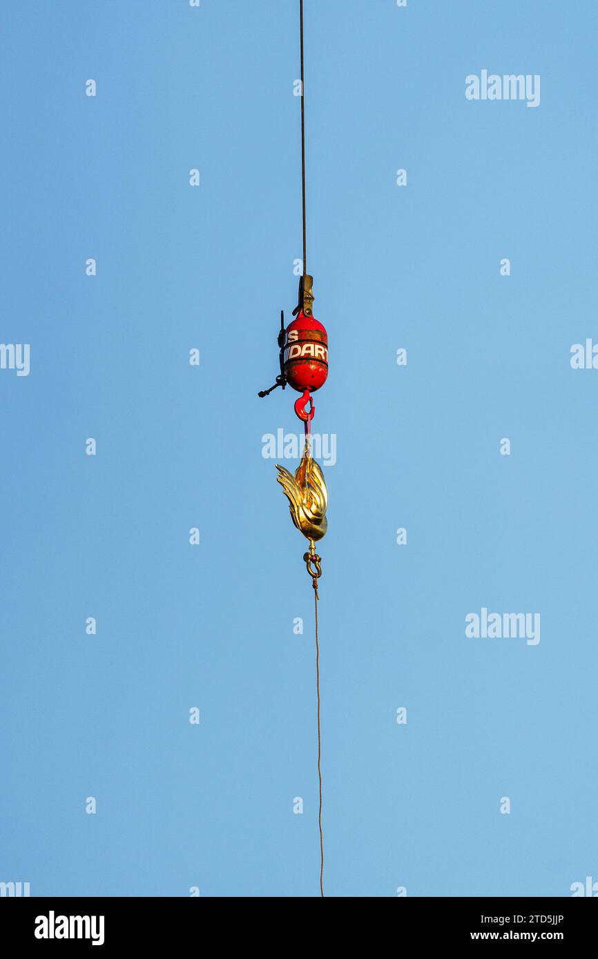 The new golden rooster containing relics is lifted by crane to be ...