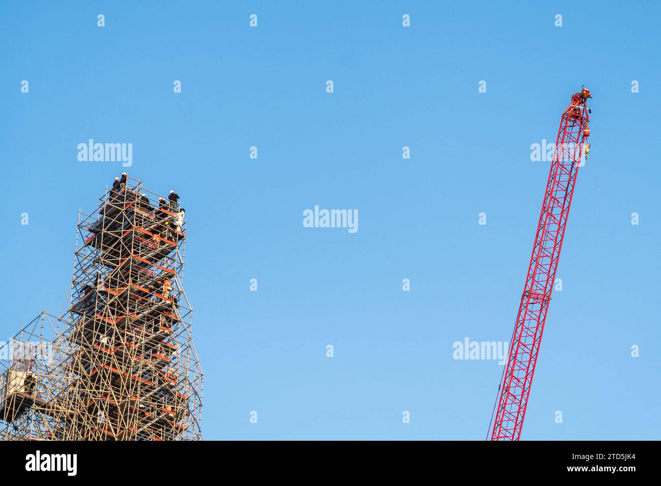 The new golden rooster containing relics is lifted by crane to be ...