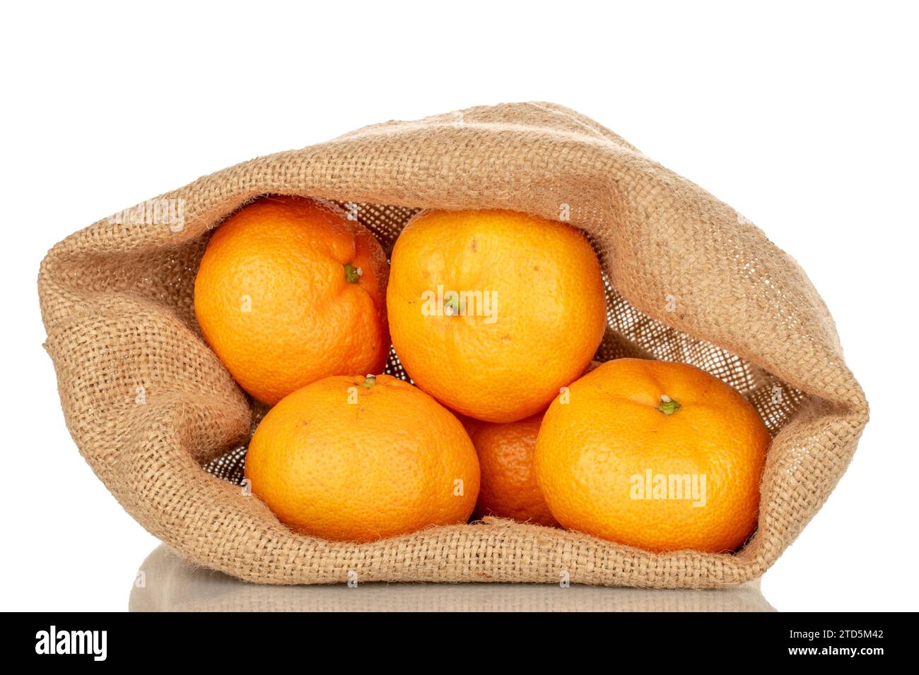 Several juicy fresh tangerines in a jute bag, macro, isolated on white ...