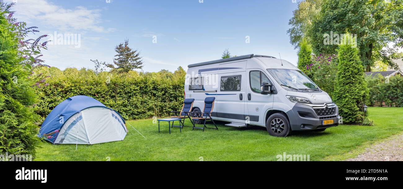 White bus camper and little blue tent at campingsite Stock Photo - Alamy