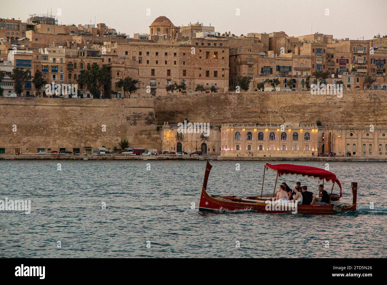 A Maltese gondola (or dghajsa) sails in front of the capital City ...