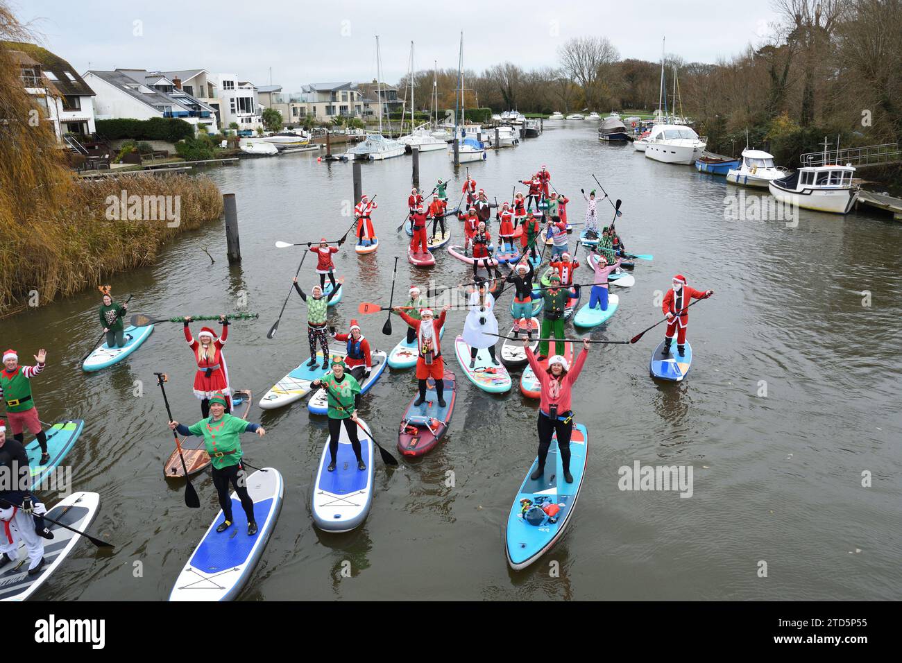 Group of paddle boarders dressed as Santa and Elves. Christmas event ...