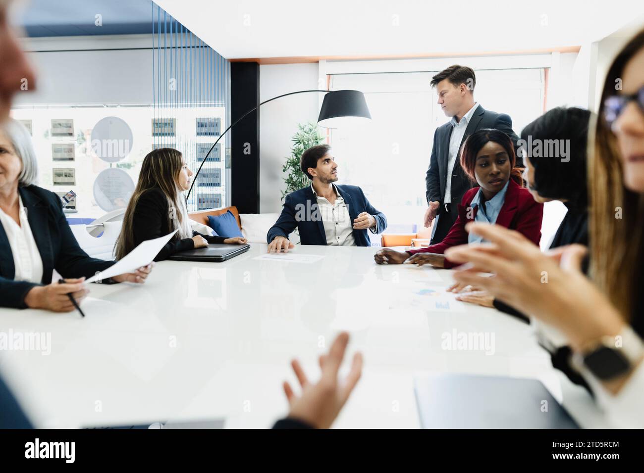 Multiracial business team doing a briefing in boardroom of modern ...