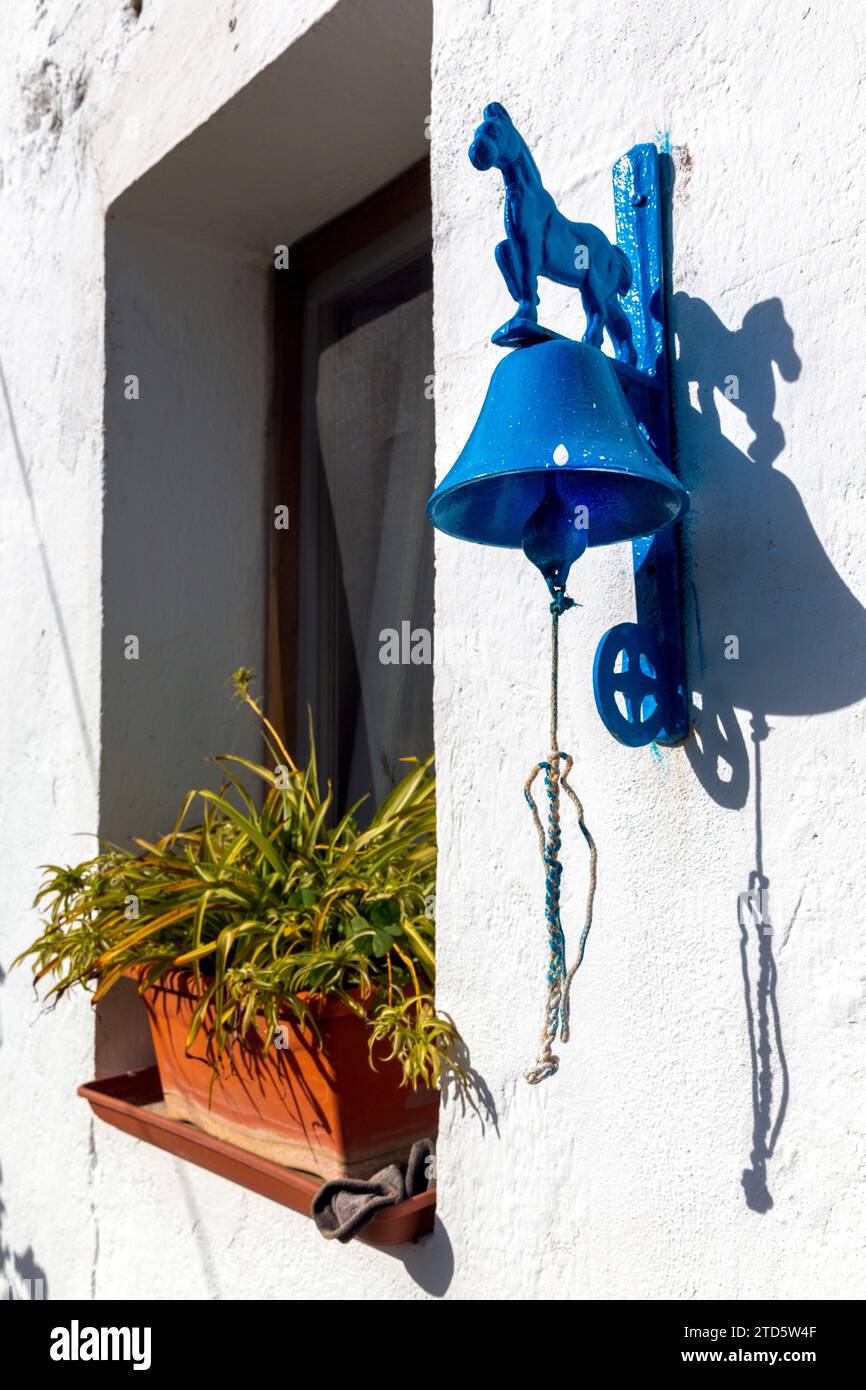 Blue painted iron bell with horse decorating the entrance of a ...