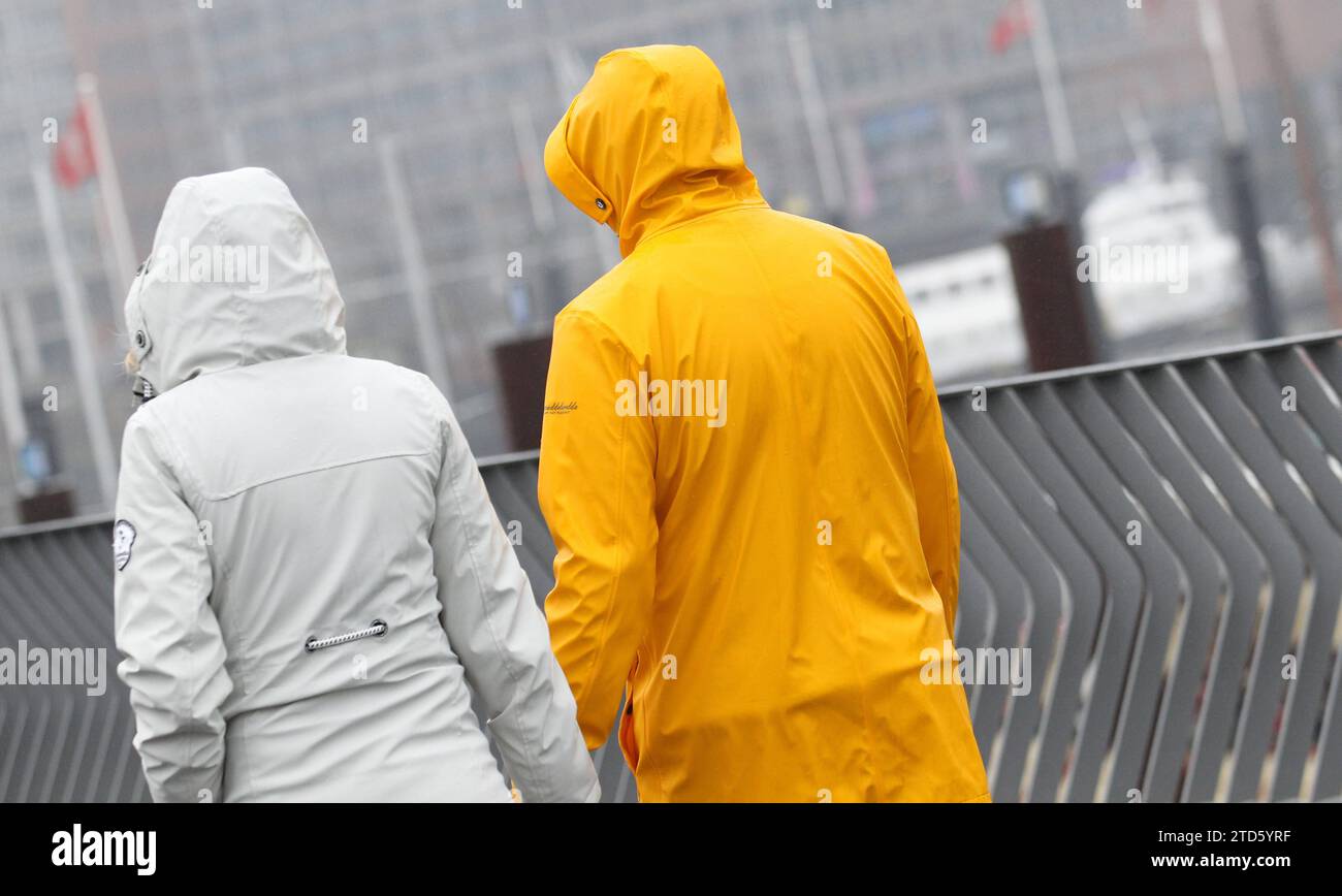 Passanten gehen bei Hamburger Schietwetter die Jan-Fedder-Promenade ...