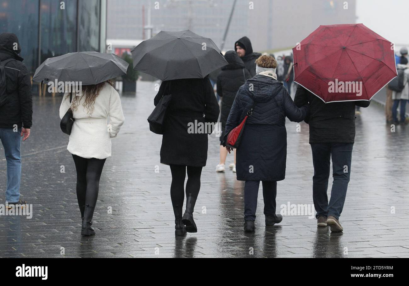 Passanten gehen bei Hamburger Schietwetter die Jan-Fedder-Promenade ...