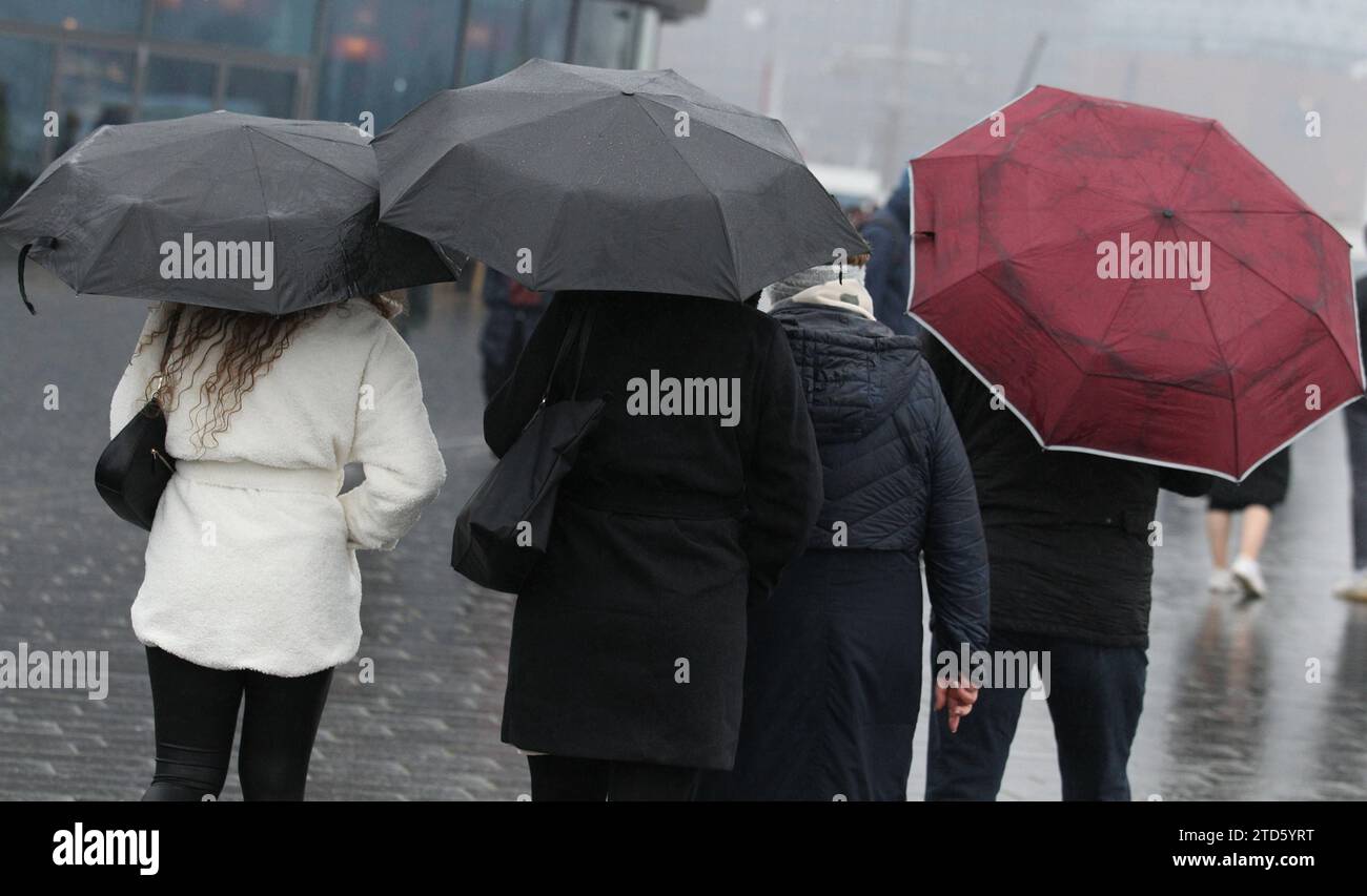 Passanten gehen bei Hamburger Schietwetter die Jan-Fedder-Promenade ...