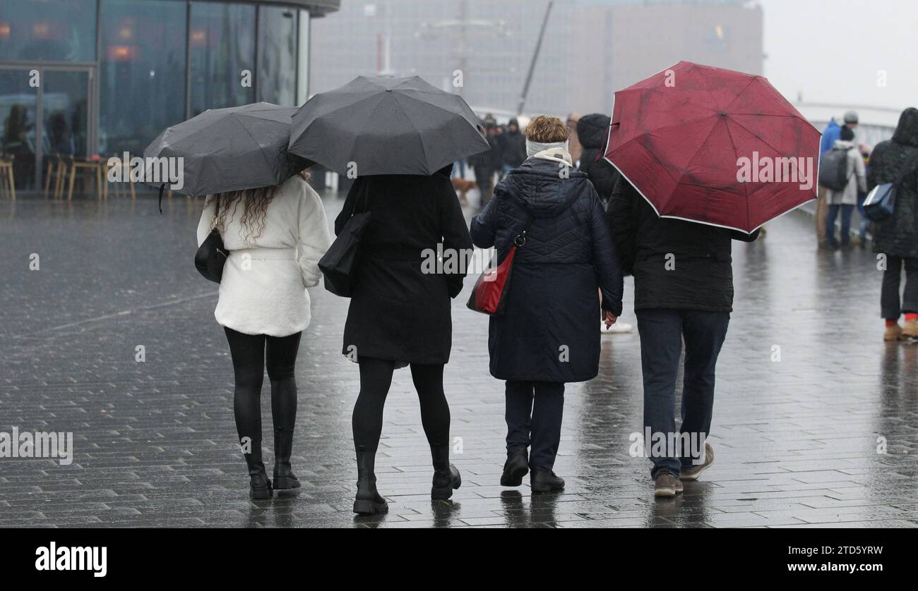 Passanten gehen bei Hamburger Schietwetter die Jan-Fedder-Promenade ...