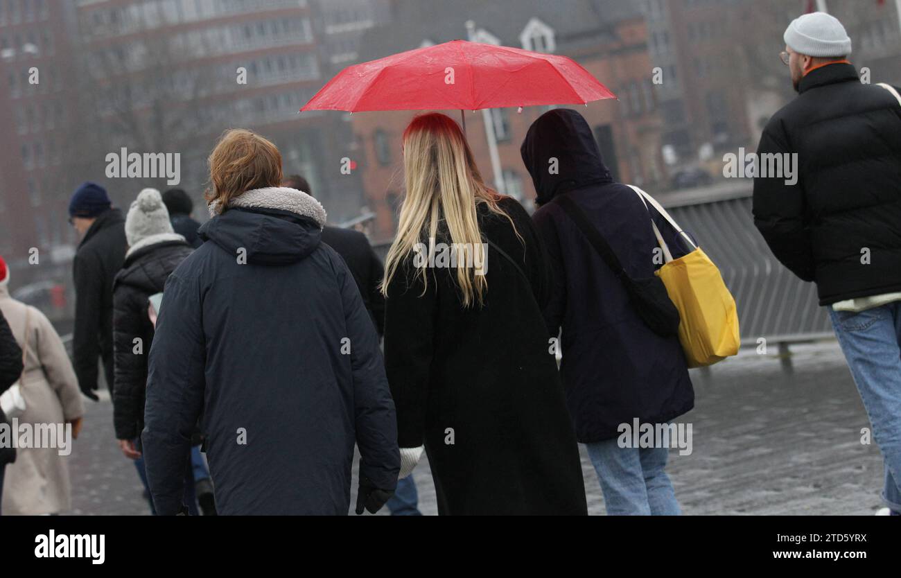 Passanten gehen bei Hamburger Schietwetter die Jan-Fedder-Promenade ...