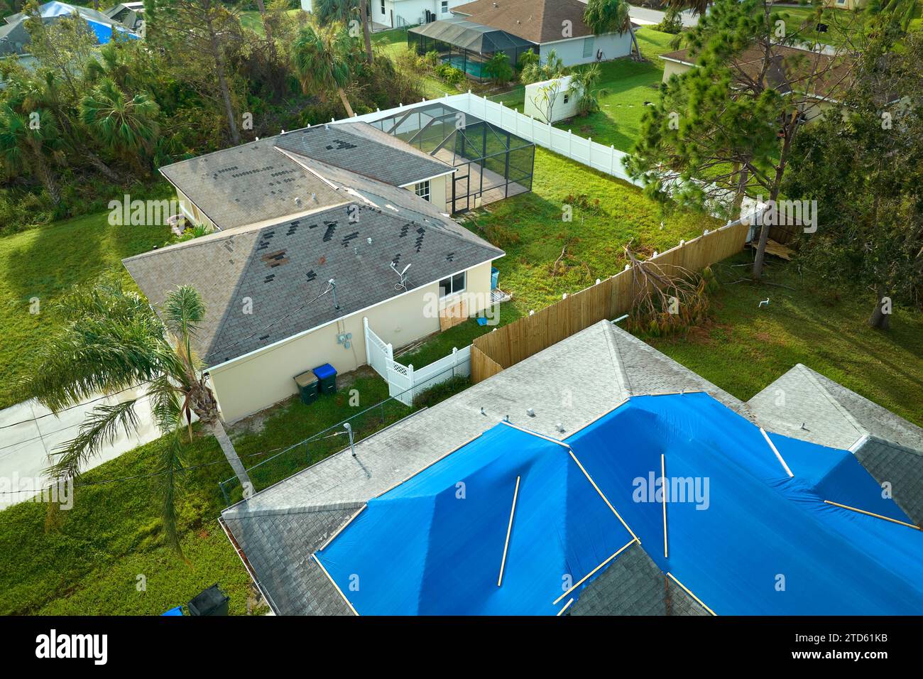 Aerial view of damaged in hurricane Ian house roof covered with blue ...