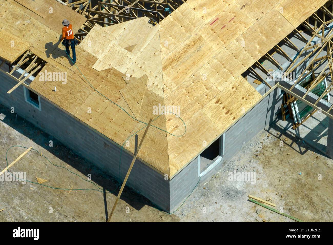 Builders working on roof construction of unfinished residential house ...