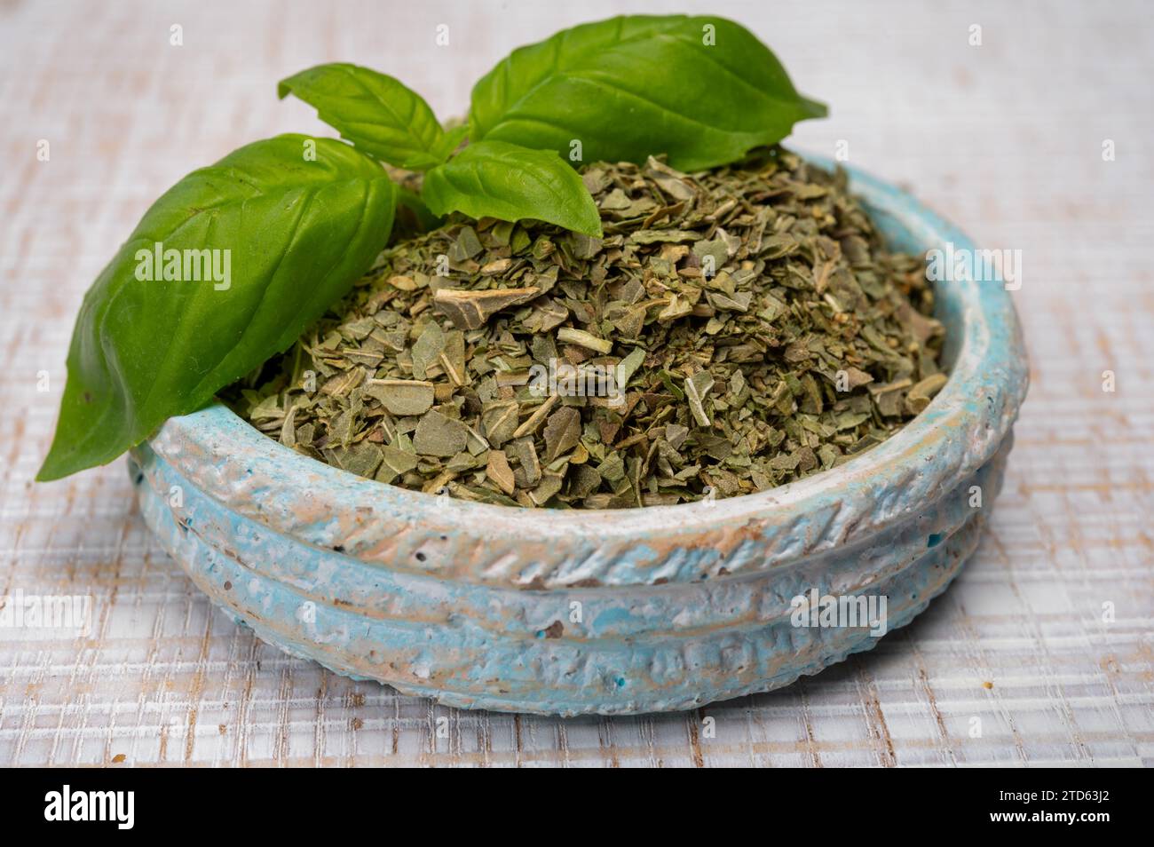 Dried crushed and whole fresh leaves of green aromatic basil plant used ...