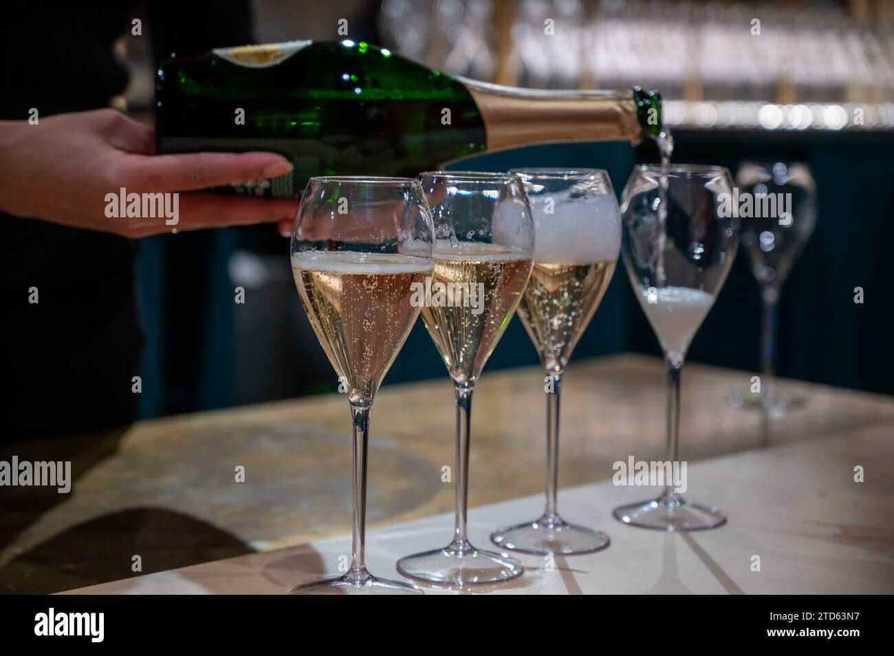 Pouring and tasting of dry sparkling wine champagne on winter weekend ...